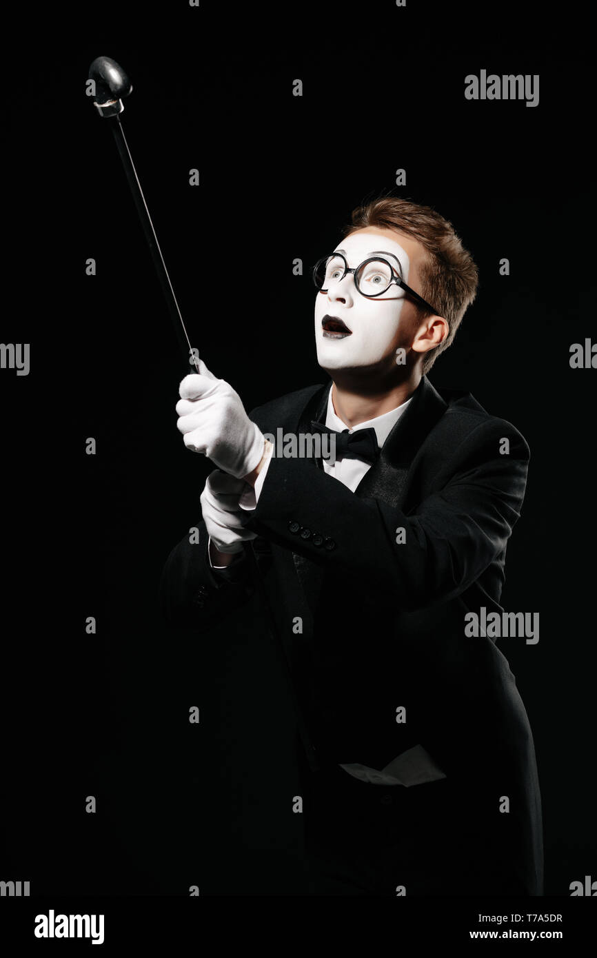 surprised mime man in tuxedo and glasses posing with walking stick on ...