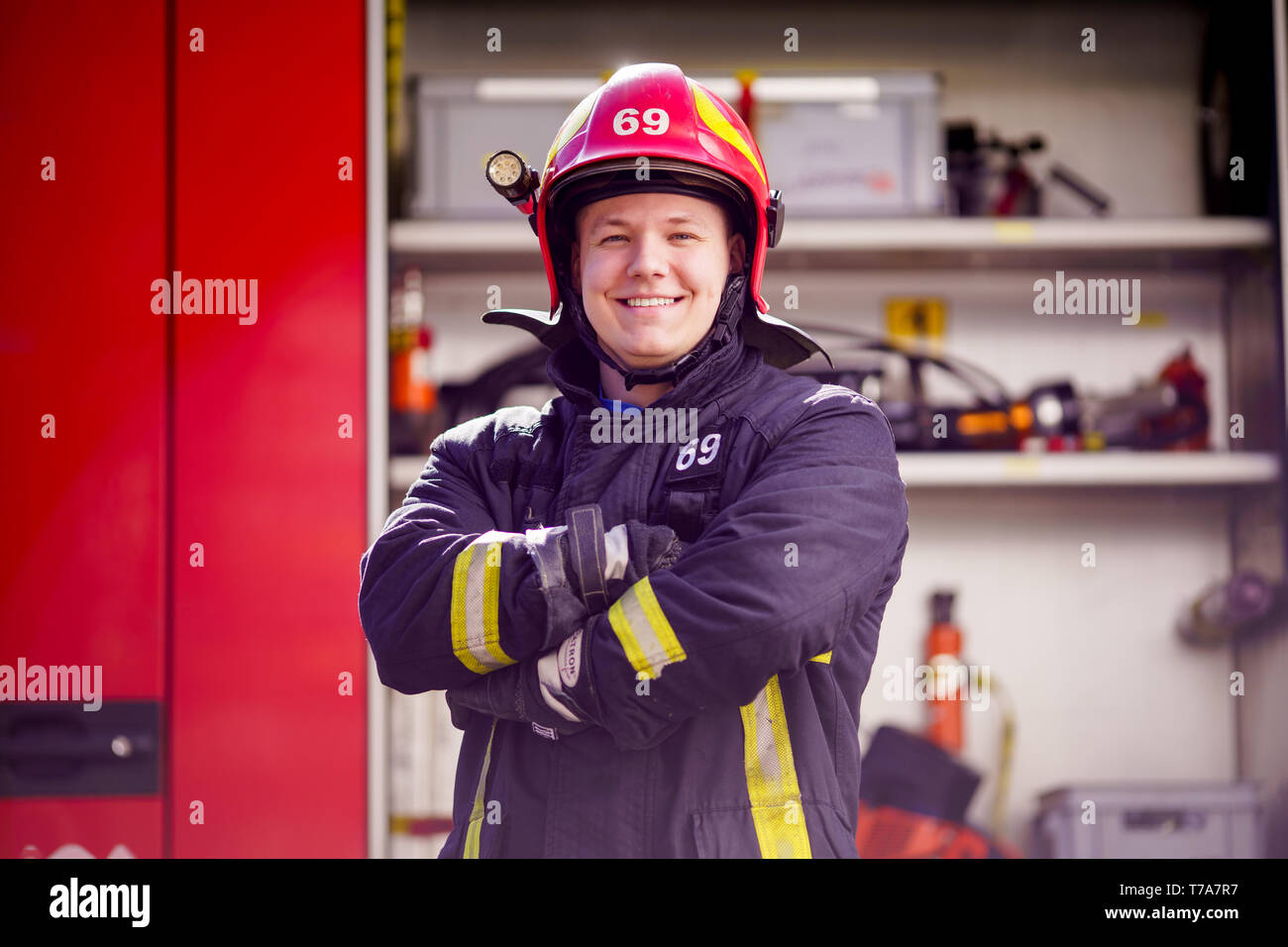 Image of happy male firefighter in helmet on background of fire truck ...
