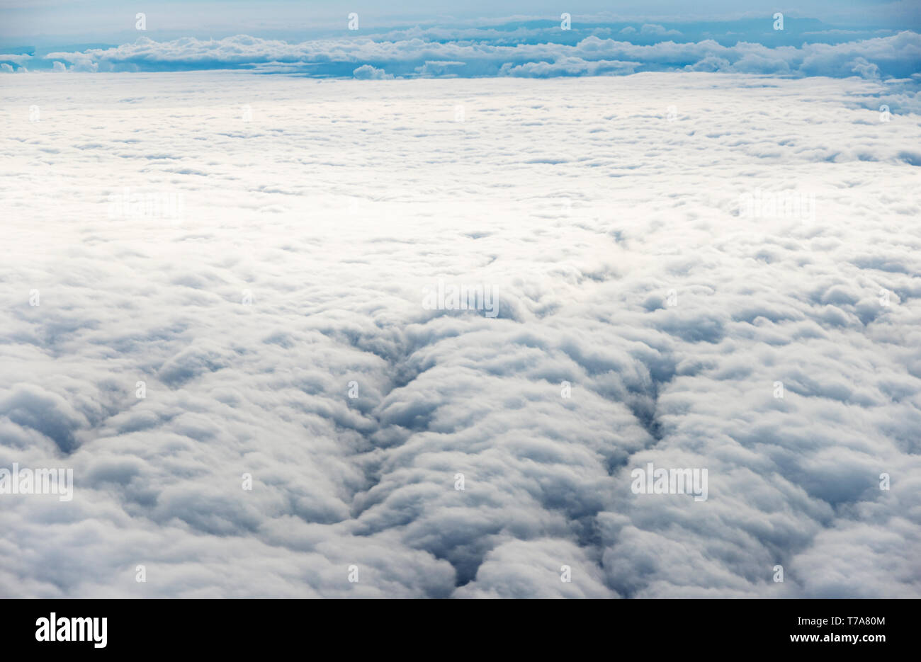 Above the fluffy clouds taken from window of a plane Stock Photo - Alamy