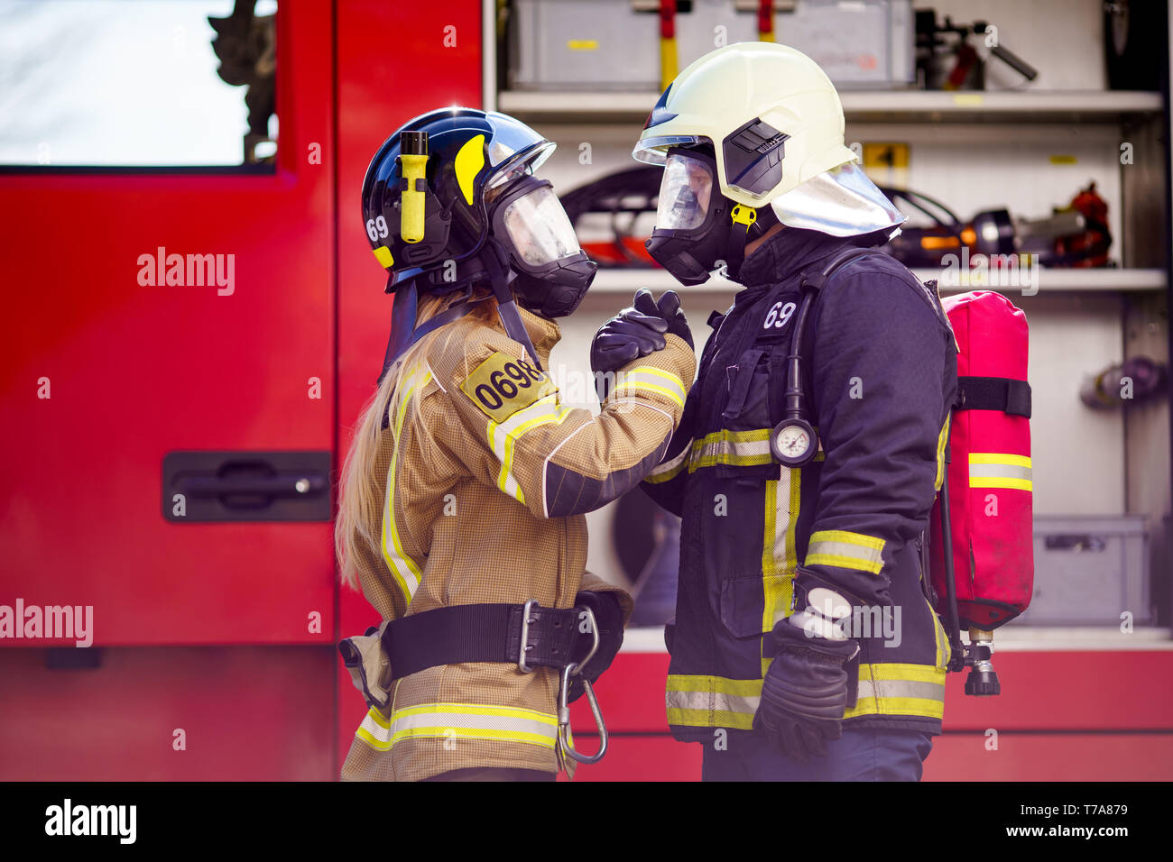 Image of firefighters women and men in helmet and mask looking at each ...