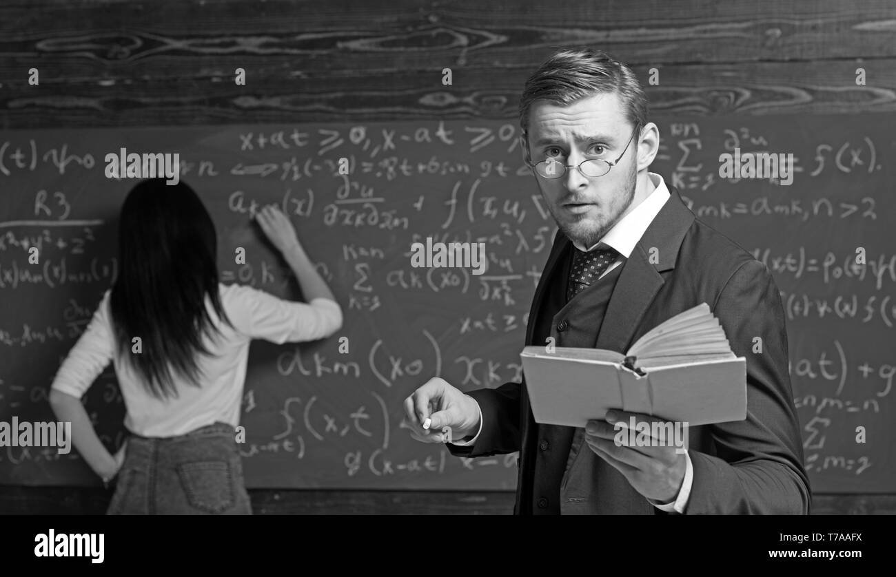 Agitated young teacher with anxious look standing in the classroom with ...