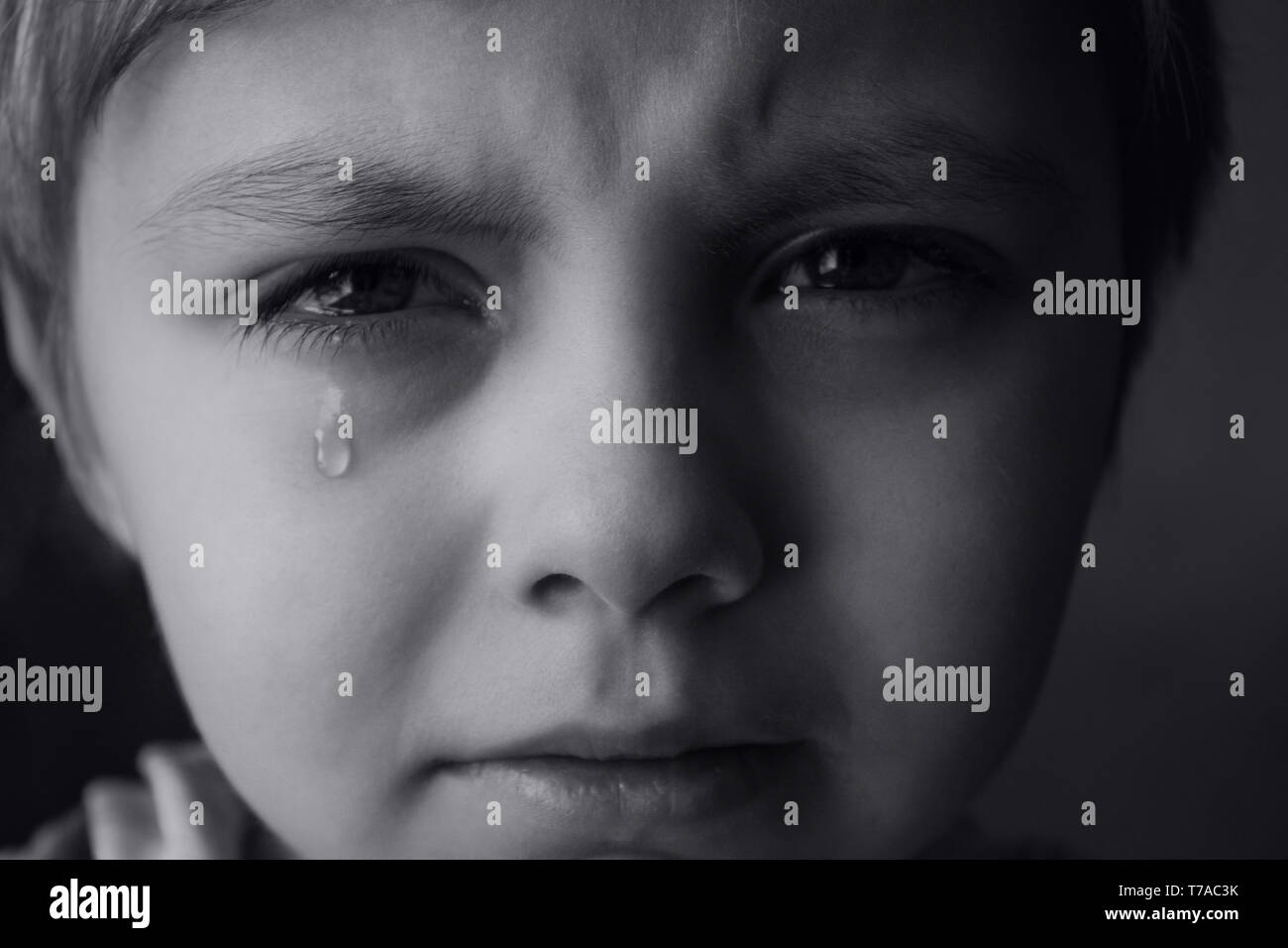 Tears in the eyes of a child. A tear on the boy's cheek. Close-up ...