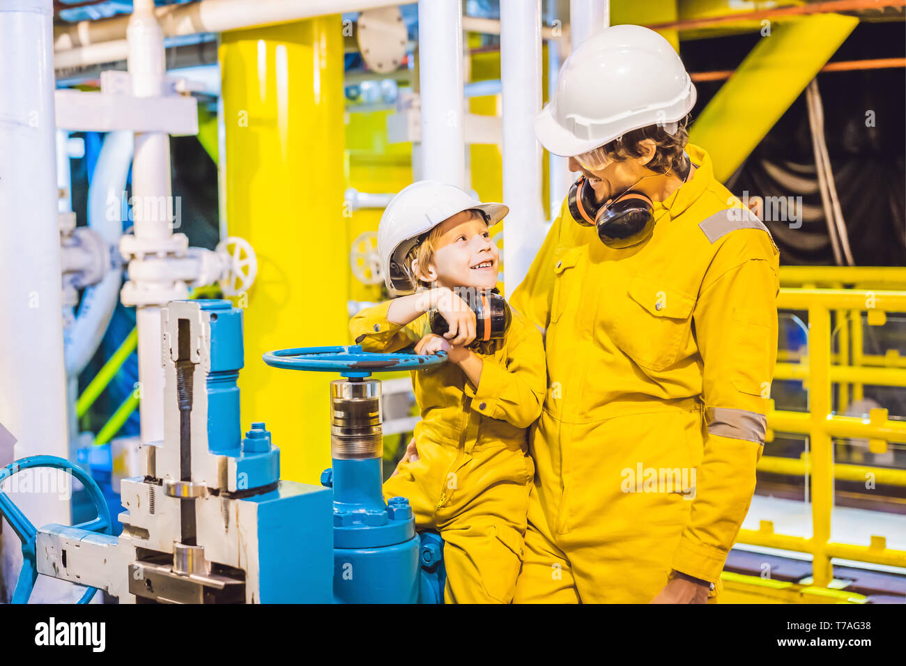 Young man and a little boy are both in a yellow work uniform, glasses ...