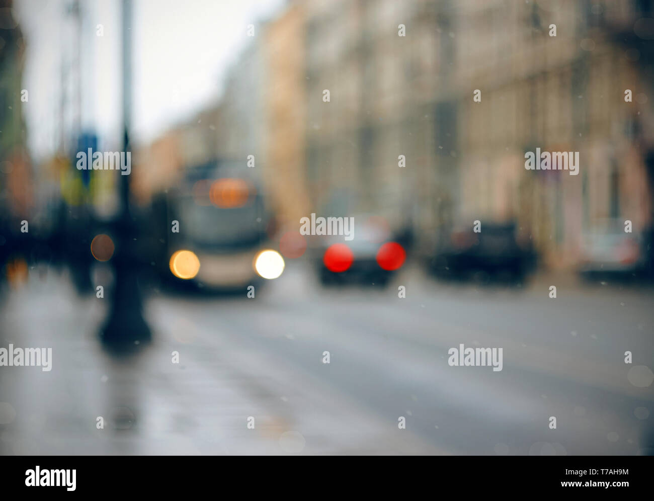 Abstract blurred background with city street, where cars and bus ride ...