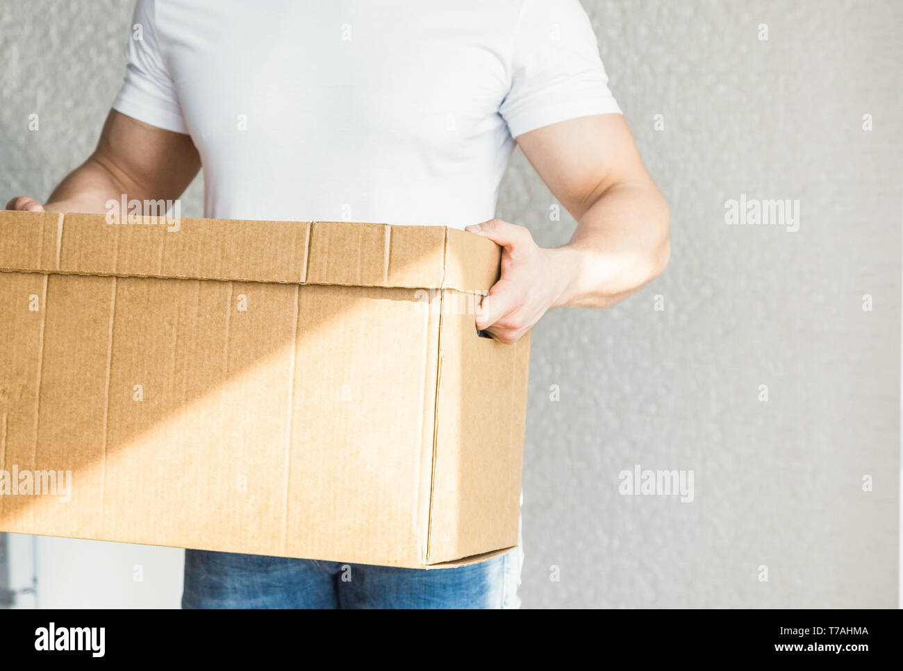 Delivery strong, muscular man loading cardboard boxes for moving to an ...