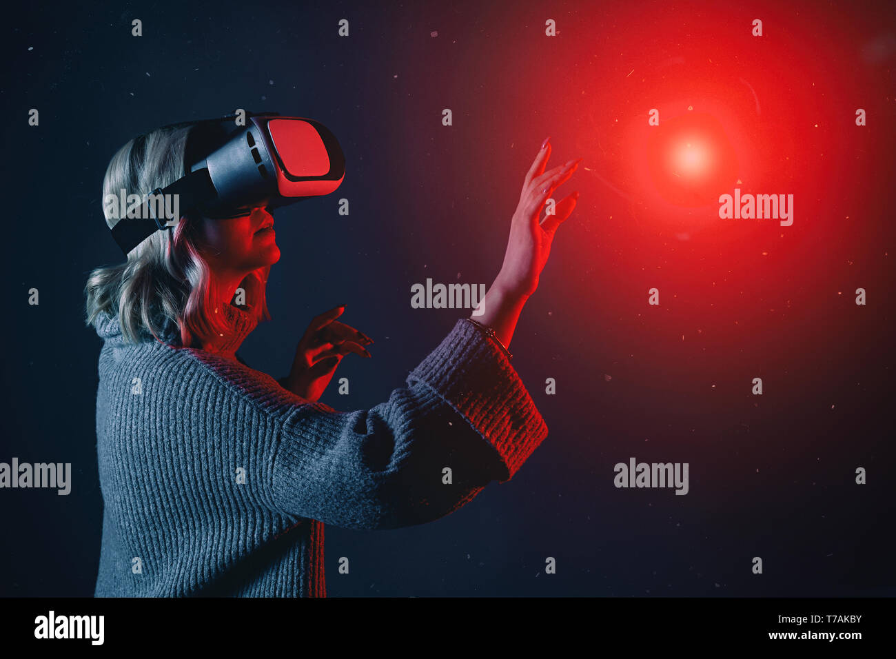 Beautiful young woman wearing a VR glasses touching imaginary object in ...