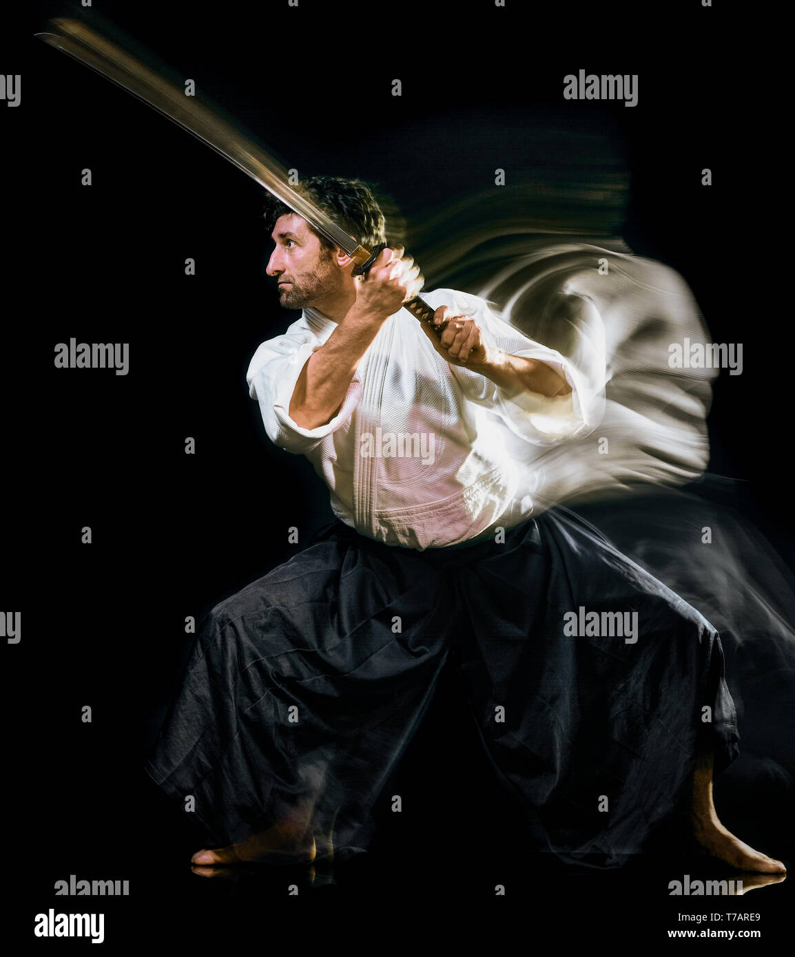 one caucasian bodoka fighters man practicing Iaido Kenjutsu studio shot ...