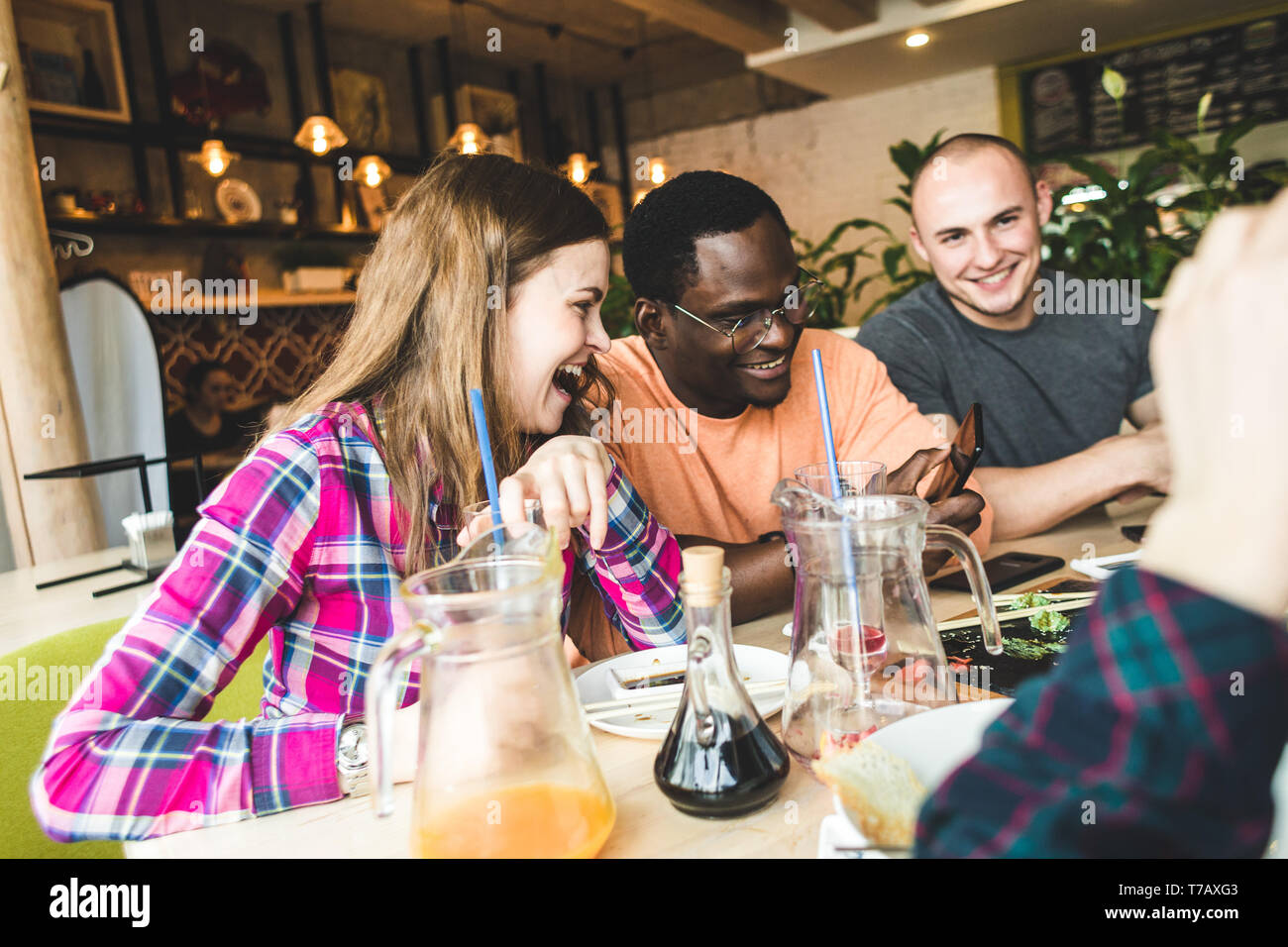 Meet young attractive people in the cafe. Friends chat, have fun, drink ...