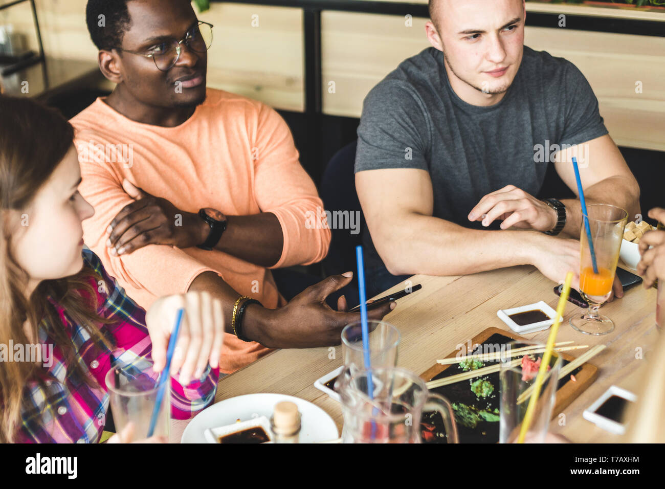 Meet young attractive people in the cafe. Friends chat, have fun, drink ...