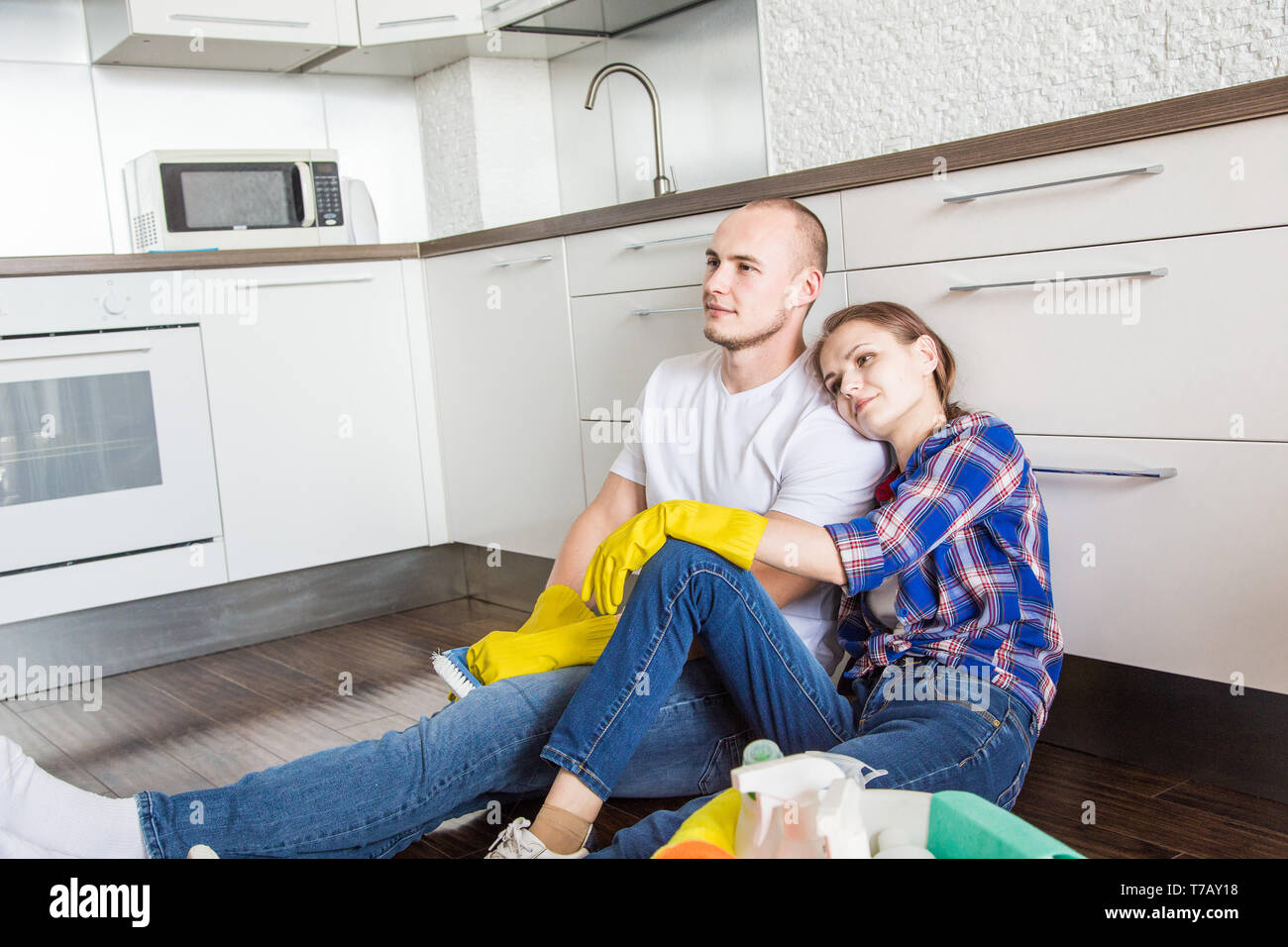 Young couple husband and wife do the house cleaning. The guy and the ...