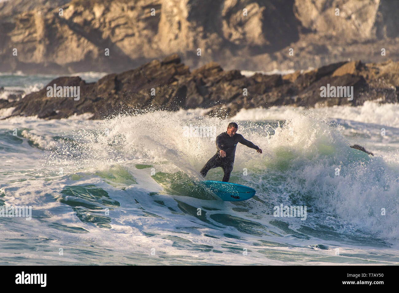A surfer carving a wave at popular surfing hotspot Fistral beach in ...