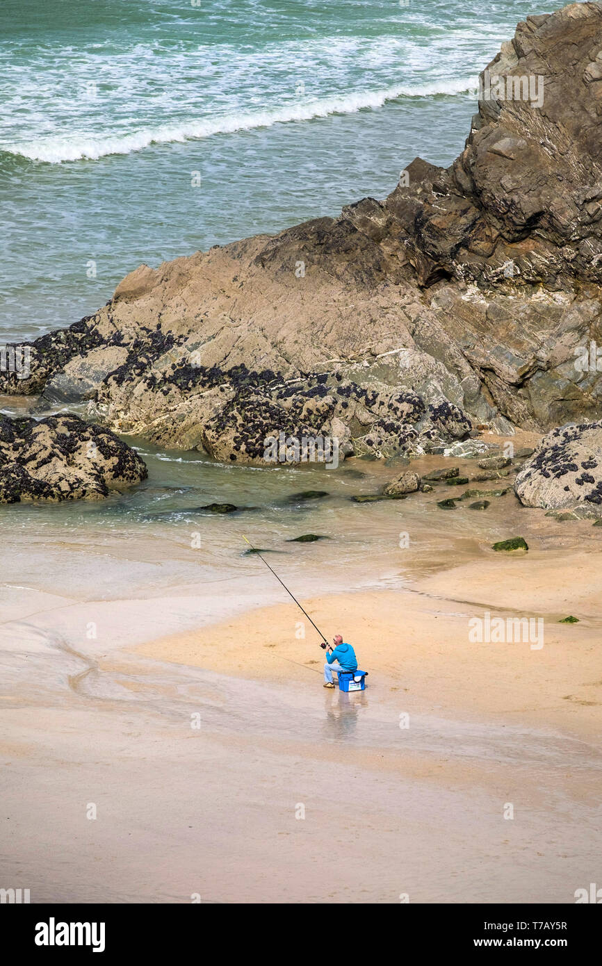 A beach angler fishing on Great Western Beach in Newquay in Cornwall ...