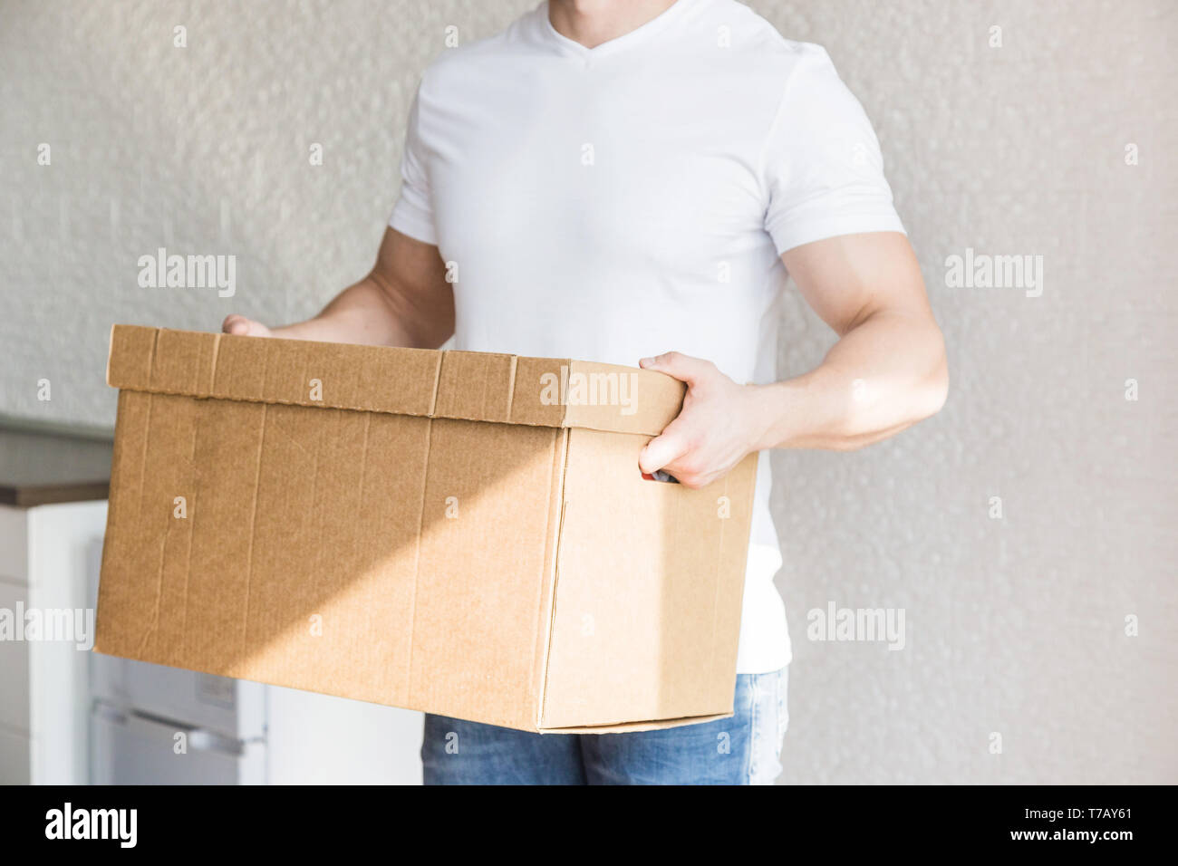 Delivery strong, muscular man loading cardboard boxes for moving to an ...