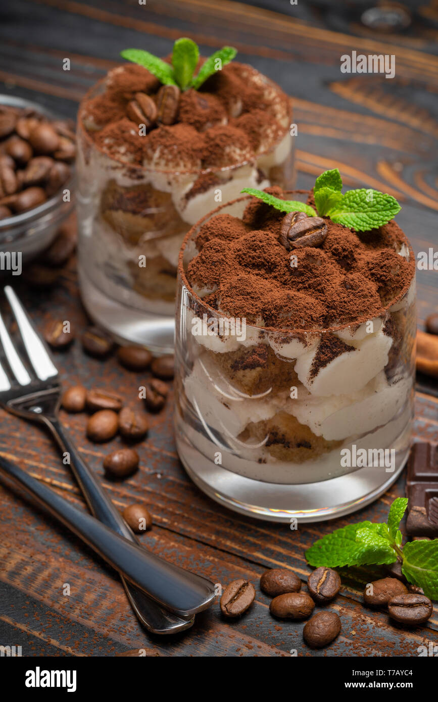 two portions Classic tiramisu dessert in a glass on wooden background ...