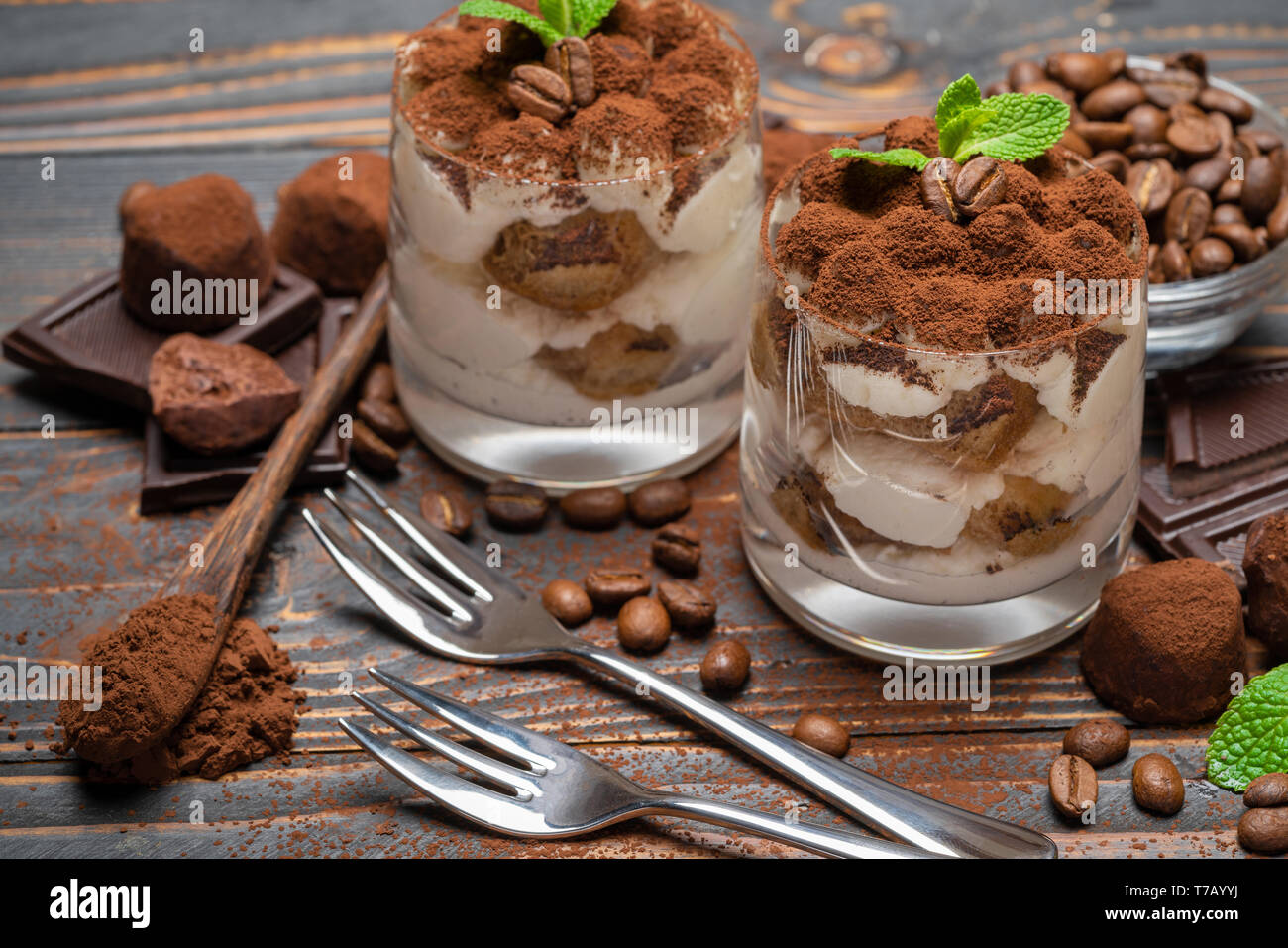 two portions Classic tiramisu dessert in a glass on wooden background ...