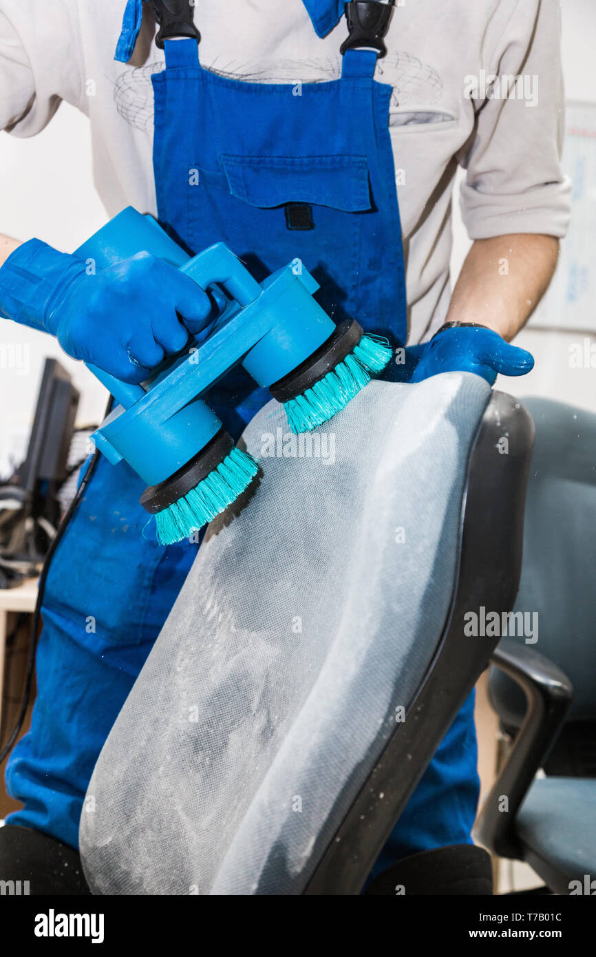 Cleaning service. Young man in workwear and rubber gloves cleans the ...
