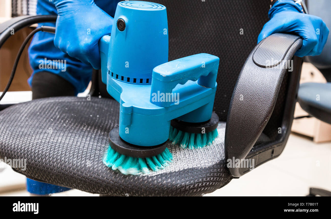 Cleaning service. Young man in workwear and rubber gloves cleans the ...
