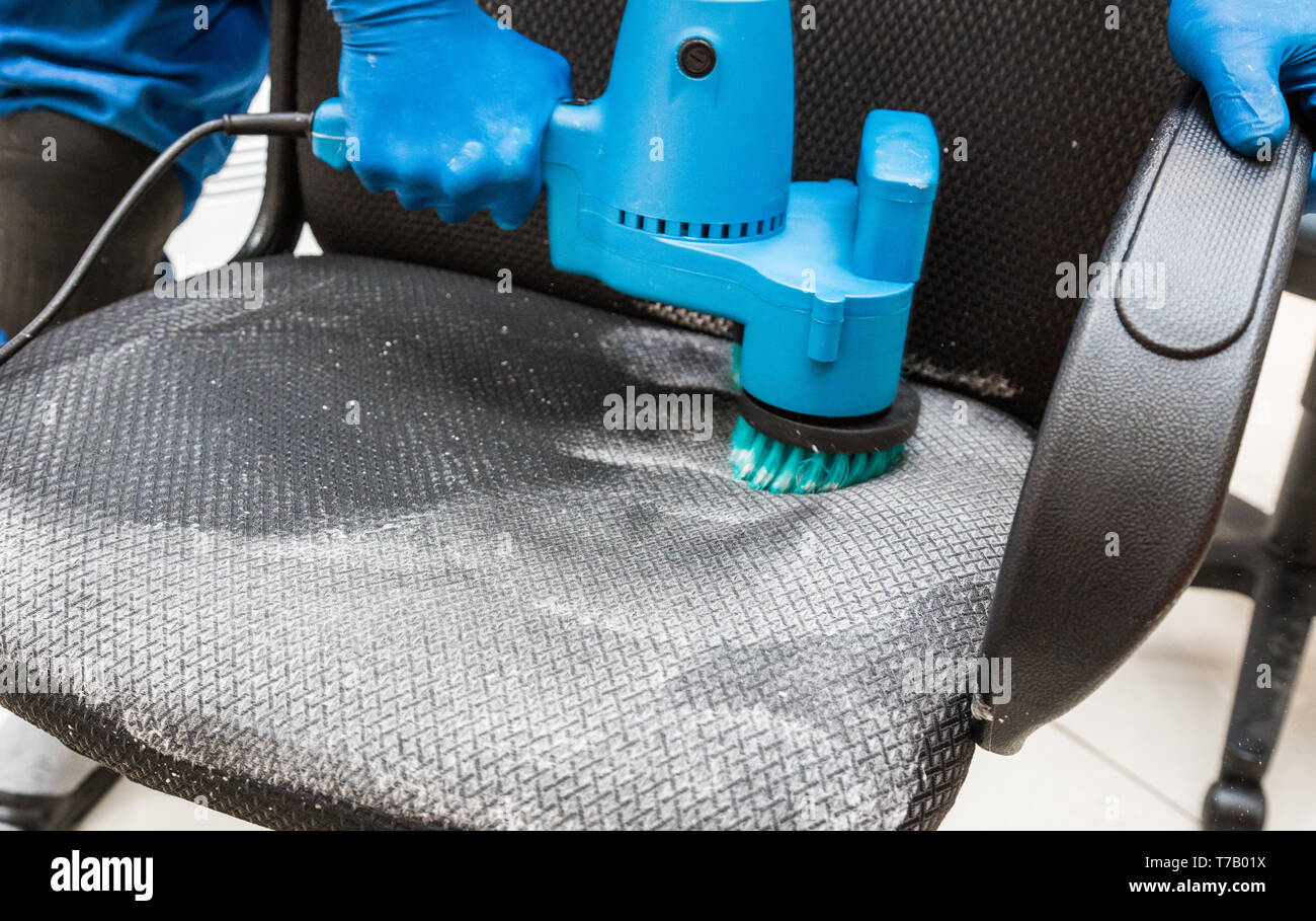 Cleaning service. Young man in workwear and rubber gloves cleans the ...