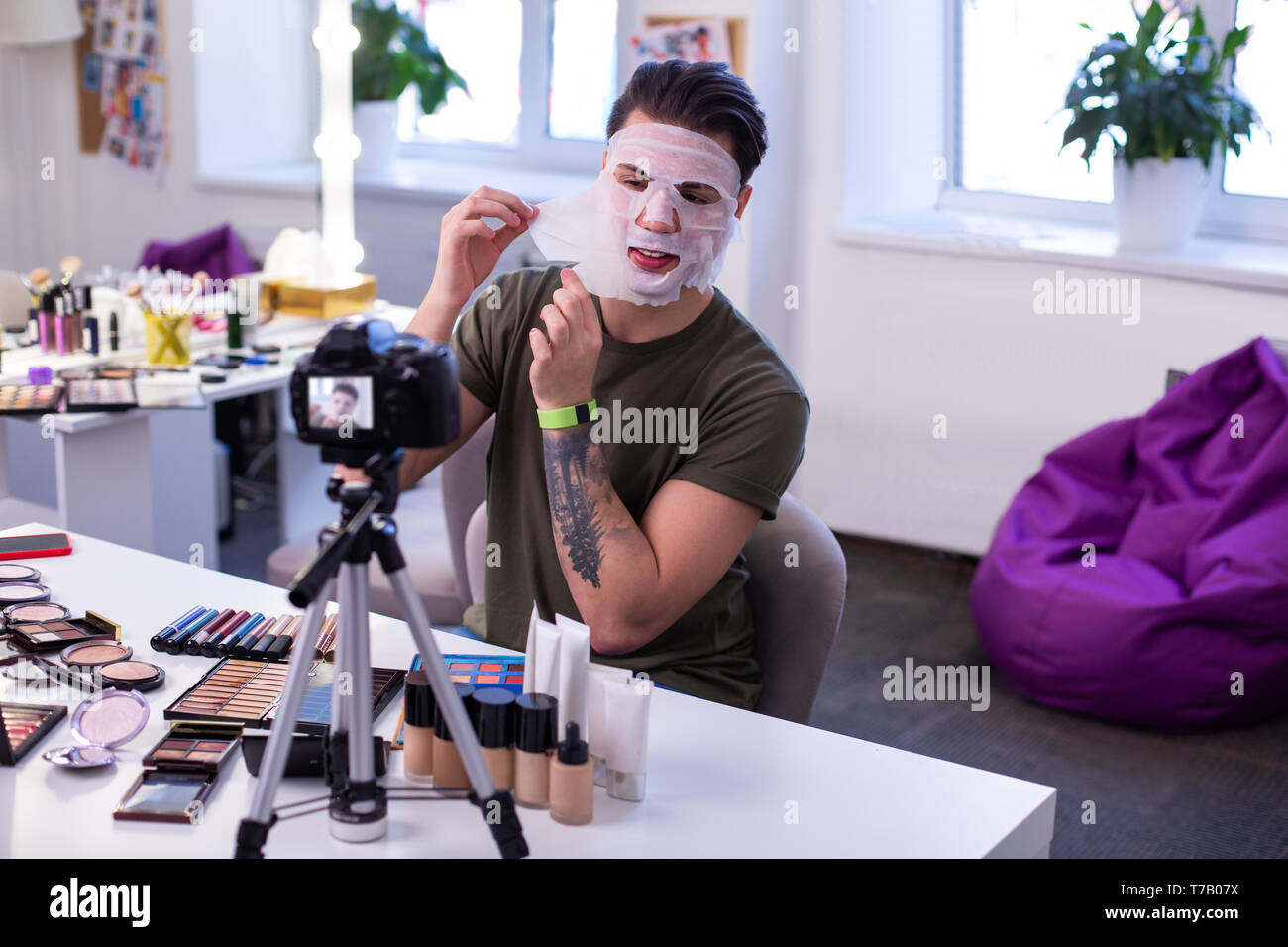 Curious communicative guy sitting in front of professional camera Stock ...