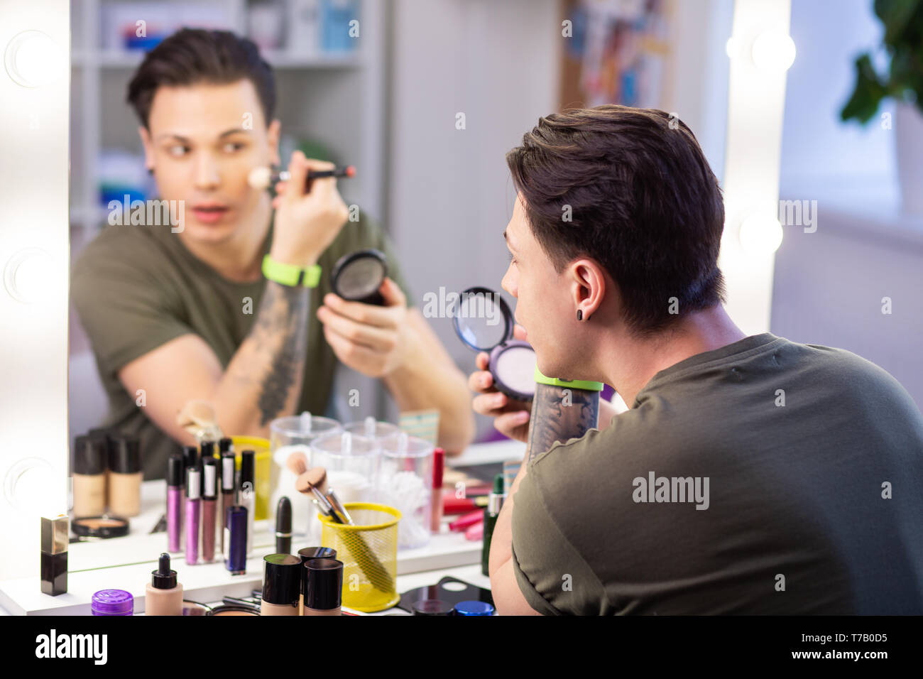 Curious handsome guy getting ready in front of mirror Stock Photo - Alamy