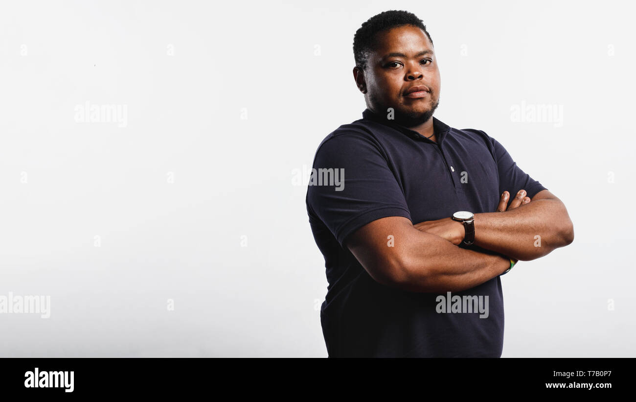 Stout african man standing against white background looking at camera ...