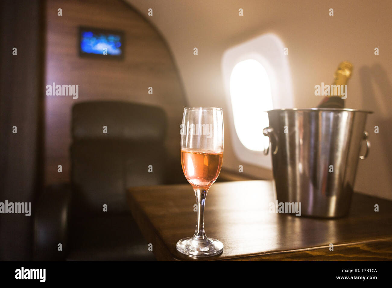 A glass of champagne in the interior of a private jet. Flying first ...