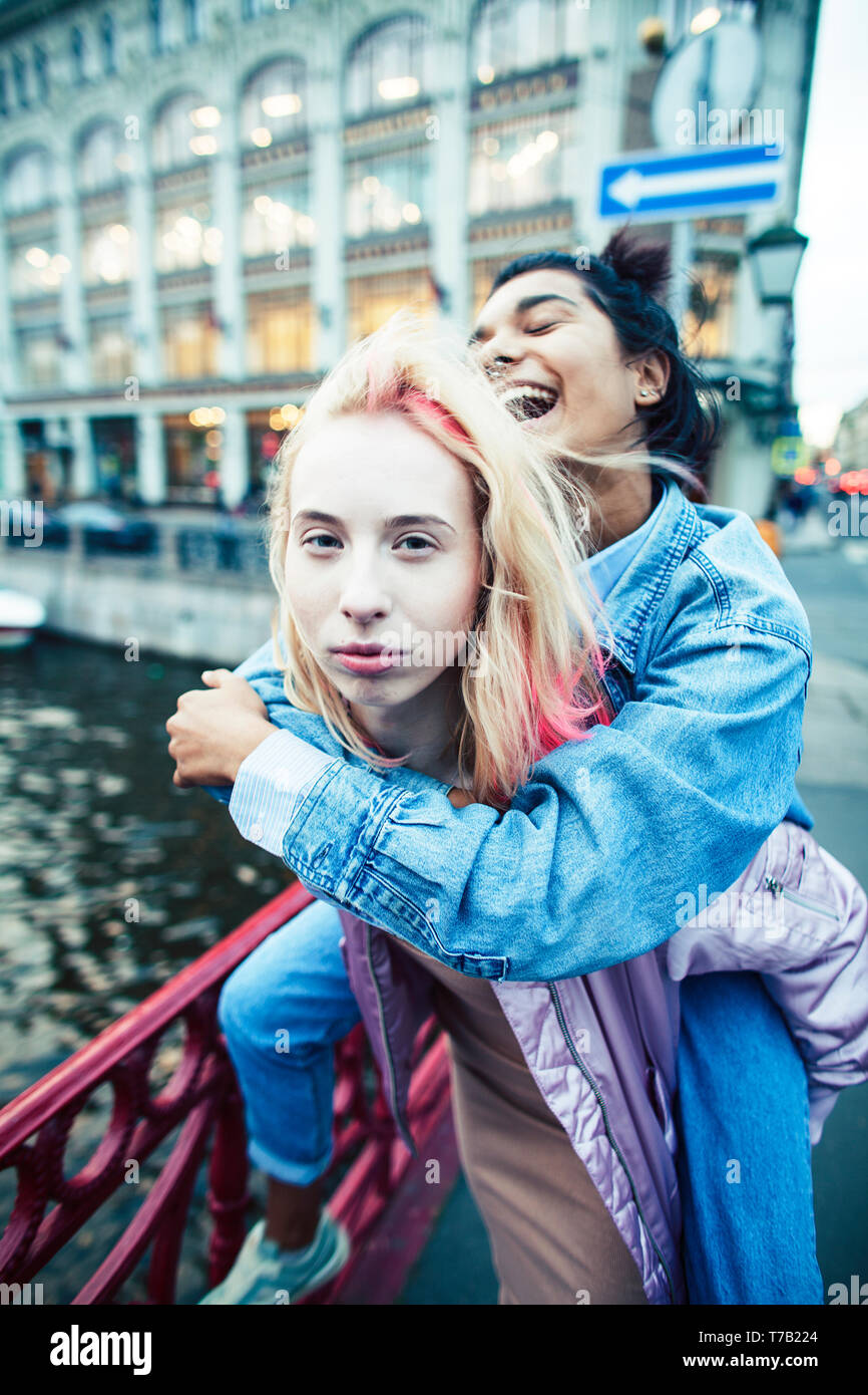 Two teenage girls infront of university building smiling, having fun ...