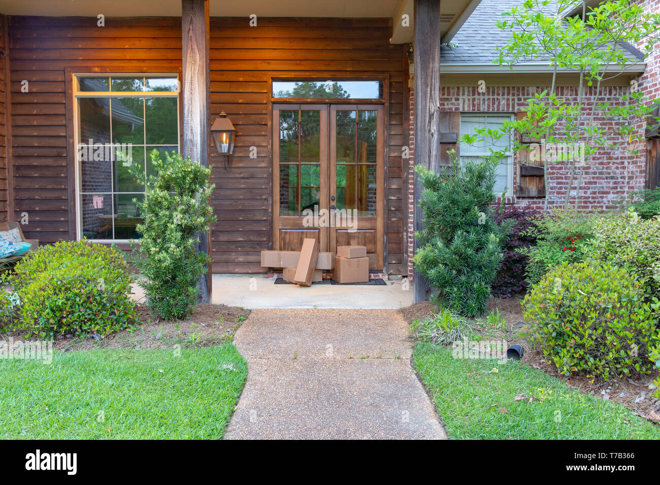 Boxes of mail on porch doorstep in front of house Stock Photo - Alamy