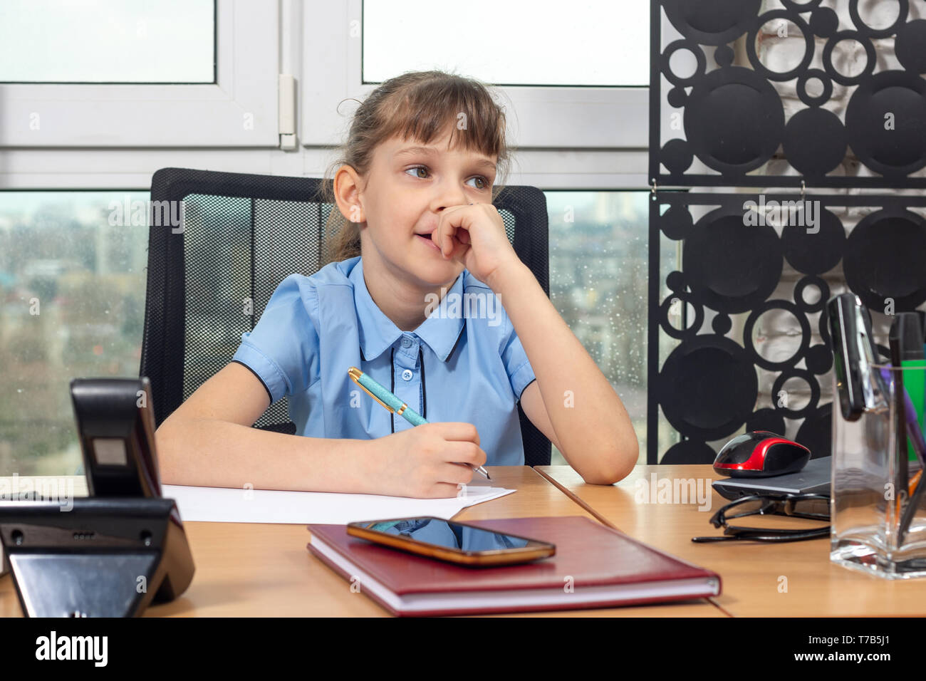 Eight-year-old girl thoughtful at the table in the office Stock Photo ...