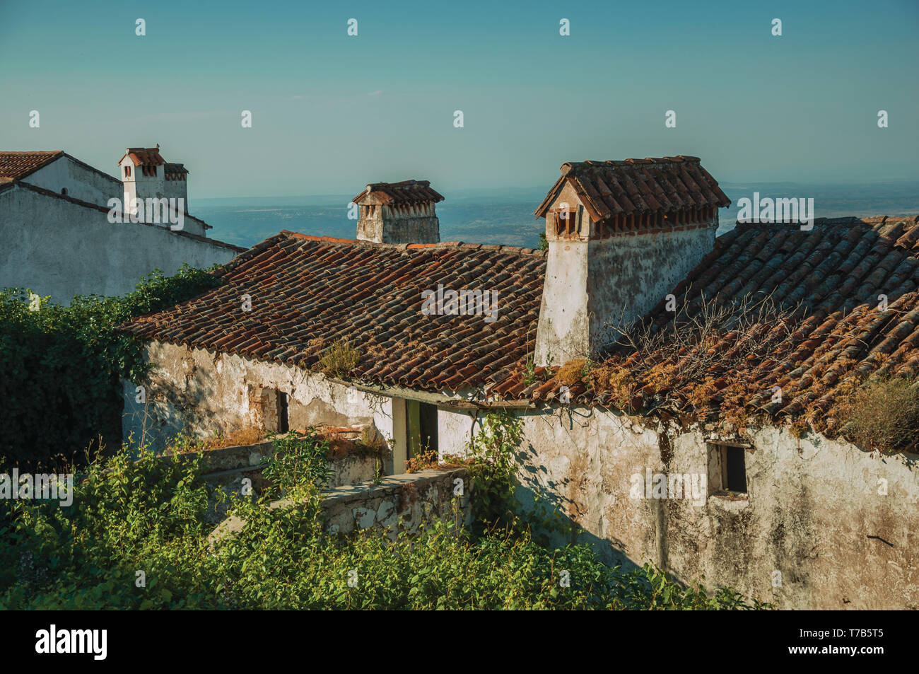 Chimneys over rooftop of a worn old house with shabby wall and ...