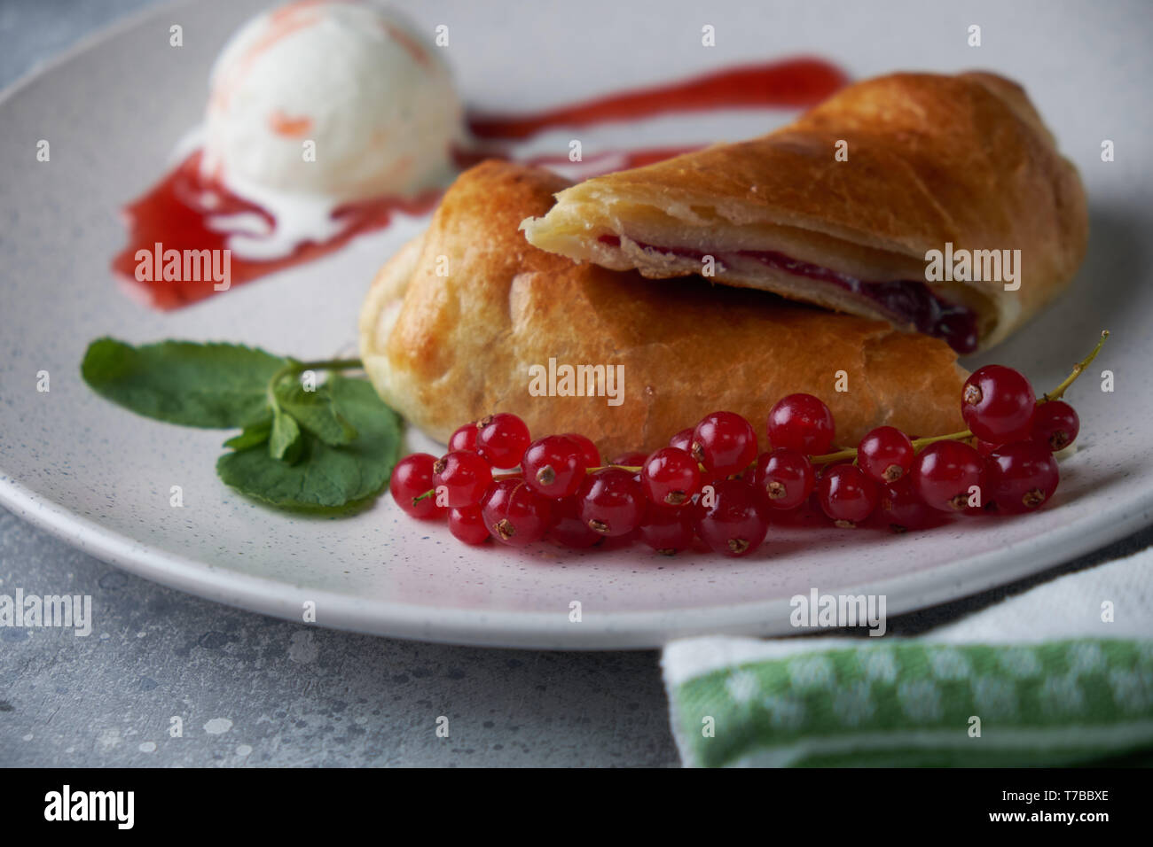 Sliced homemade berry strudel served with fresh red currant berries and ...