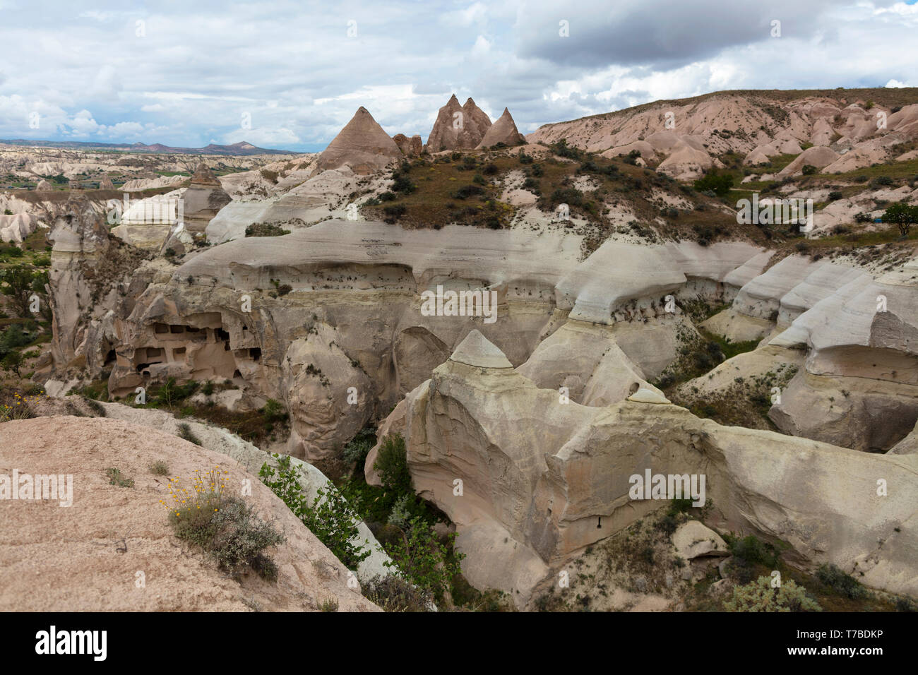 Red and white sandstone cliffs, ancient caves in a mountain landscape ...