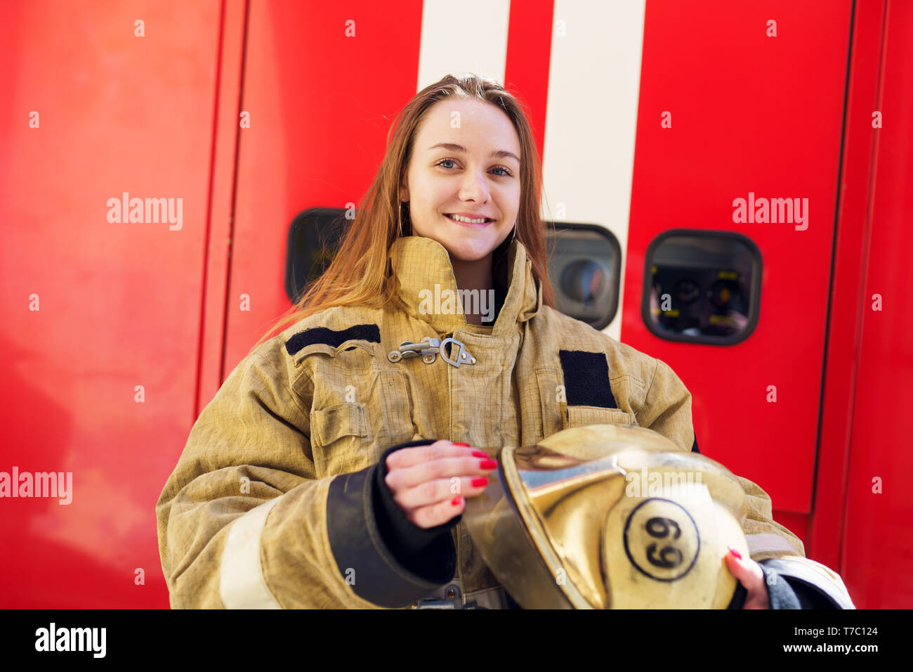 Photo of happy fire girl standing at fire truck Stock Photo - Alamy
