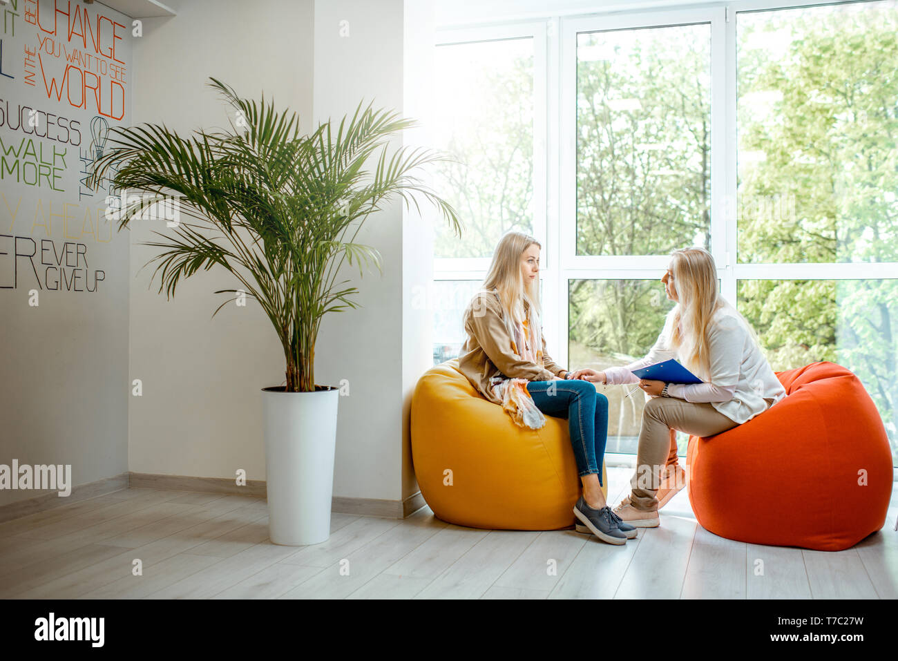 Young woman with senior female psychologist or mental coach sitting on ...