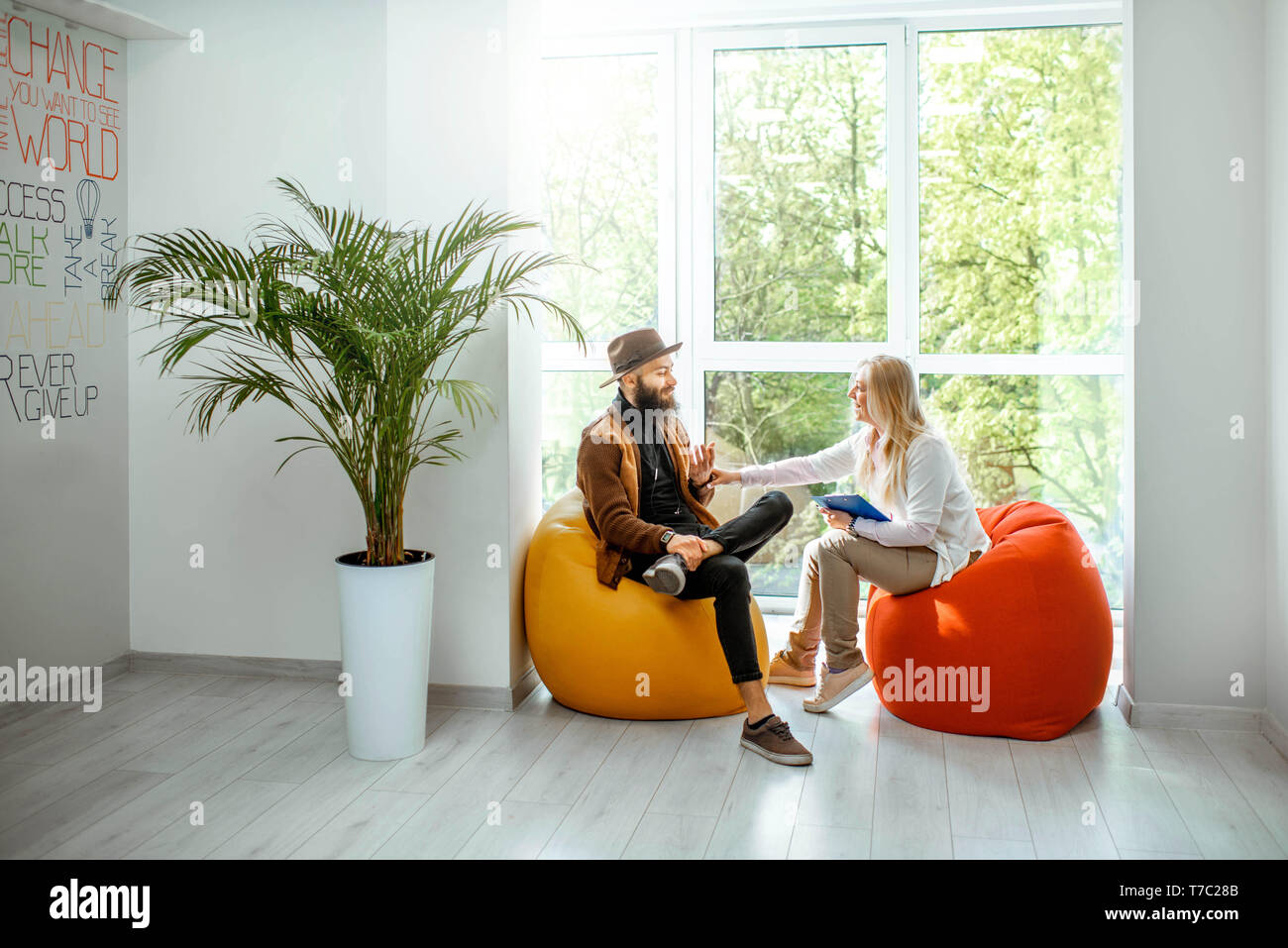 Stylish man with senior female psychologist or mental coach sitting on ...