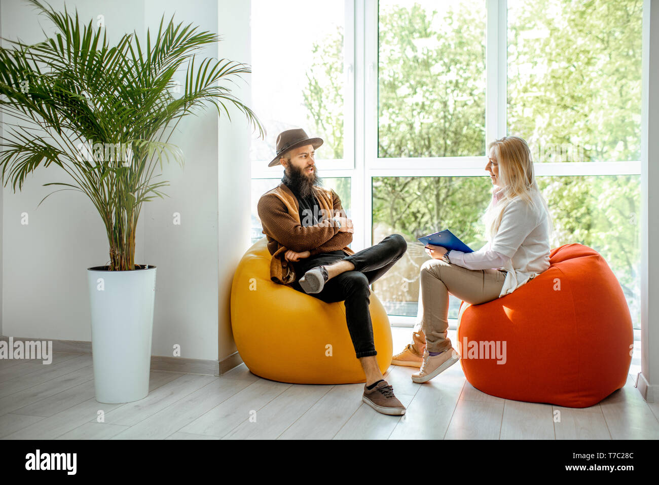 Stylish man with senior female psychologist or mental coach sitting on ...