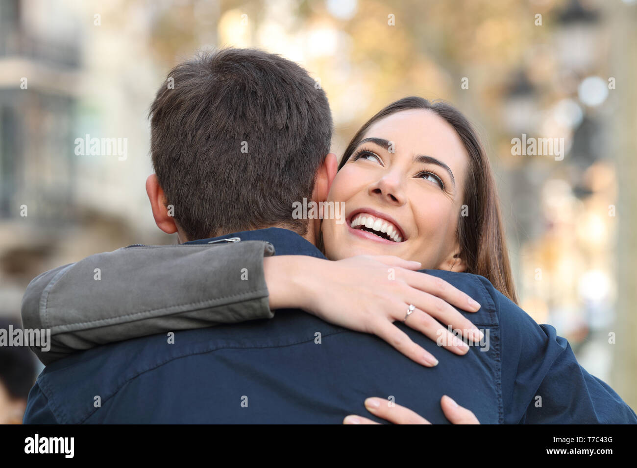Happy girl hugs her boyfriend after meeting in a city street Stock ...