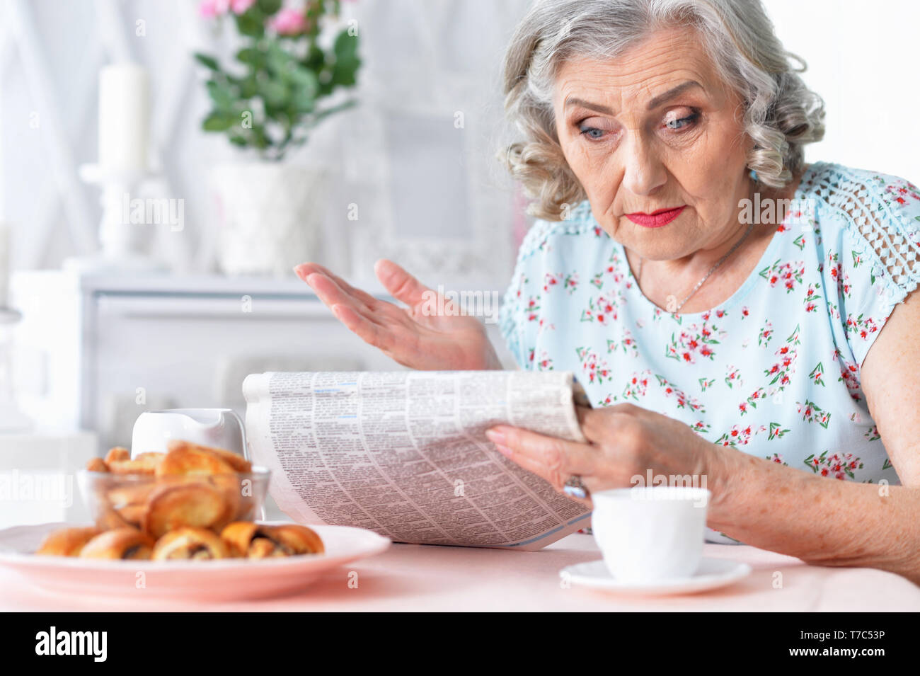 Portrait of thoughtful aged woman reading newspaper Stock Photo - Alamy