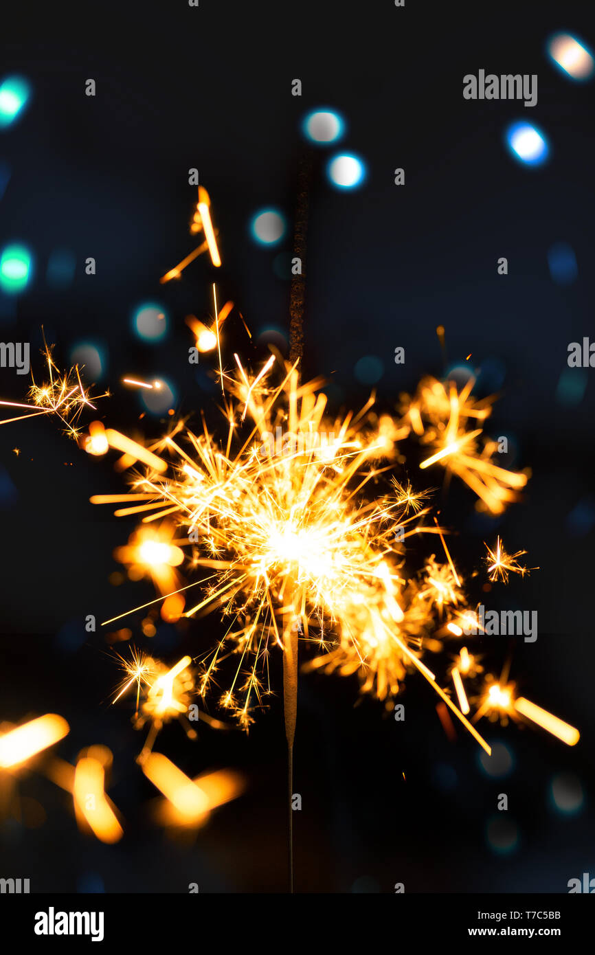 Burning sparkler with bokeh light background Stock Photo - Alamy