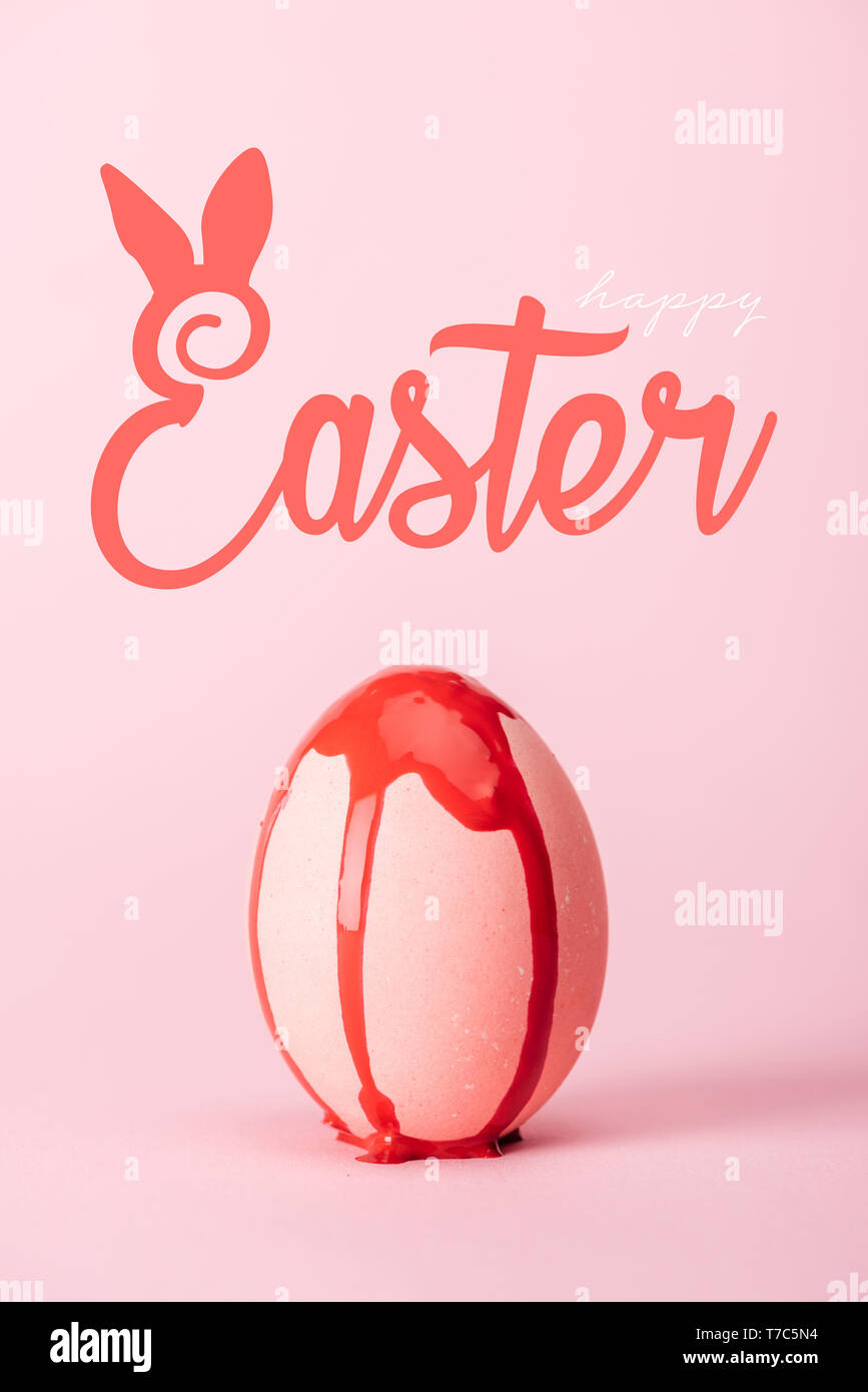 pink chicken egg with dripping red paint on pink background with happy ...