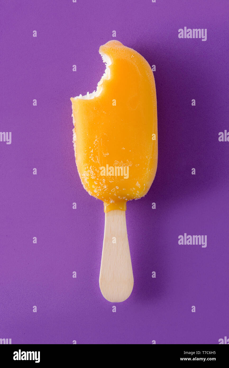 Orange popsicle on violet background Stock Photo - Alamy