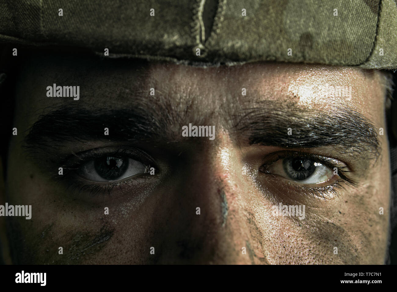 Looking deeper for a reason. Close up portrait of young male soldier ...