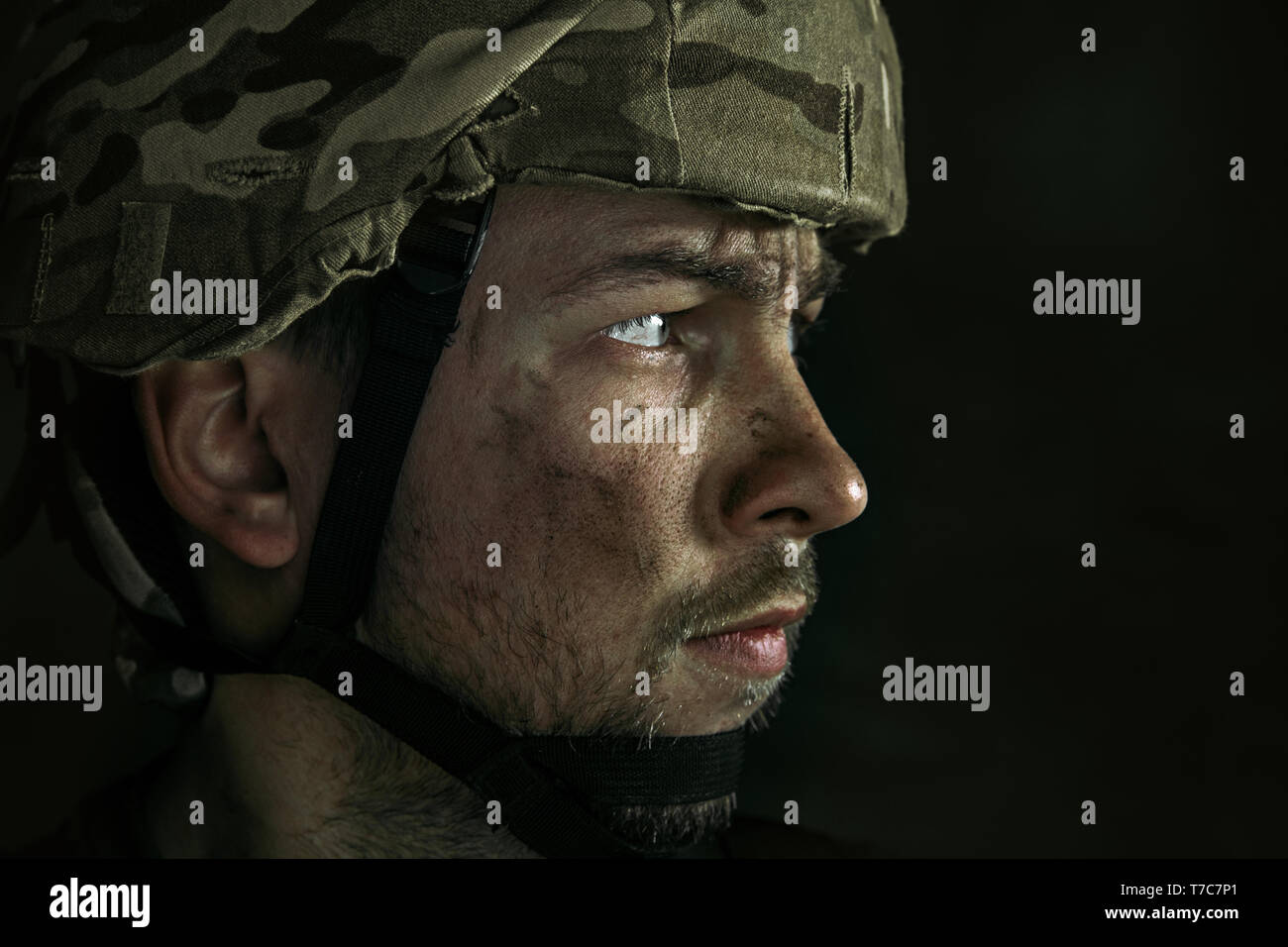 Feel the danger's coming. Close up portrait of young male soldier. Man ...