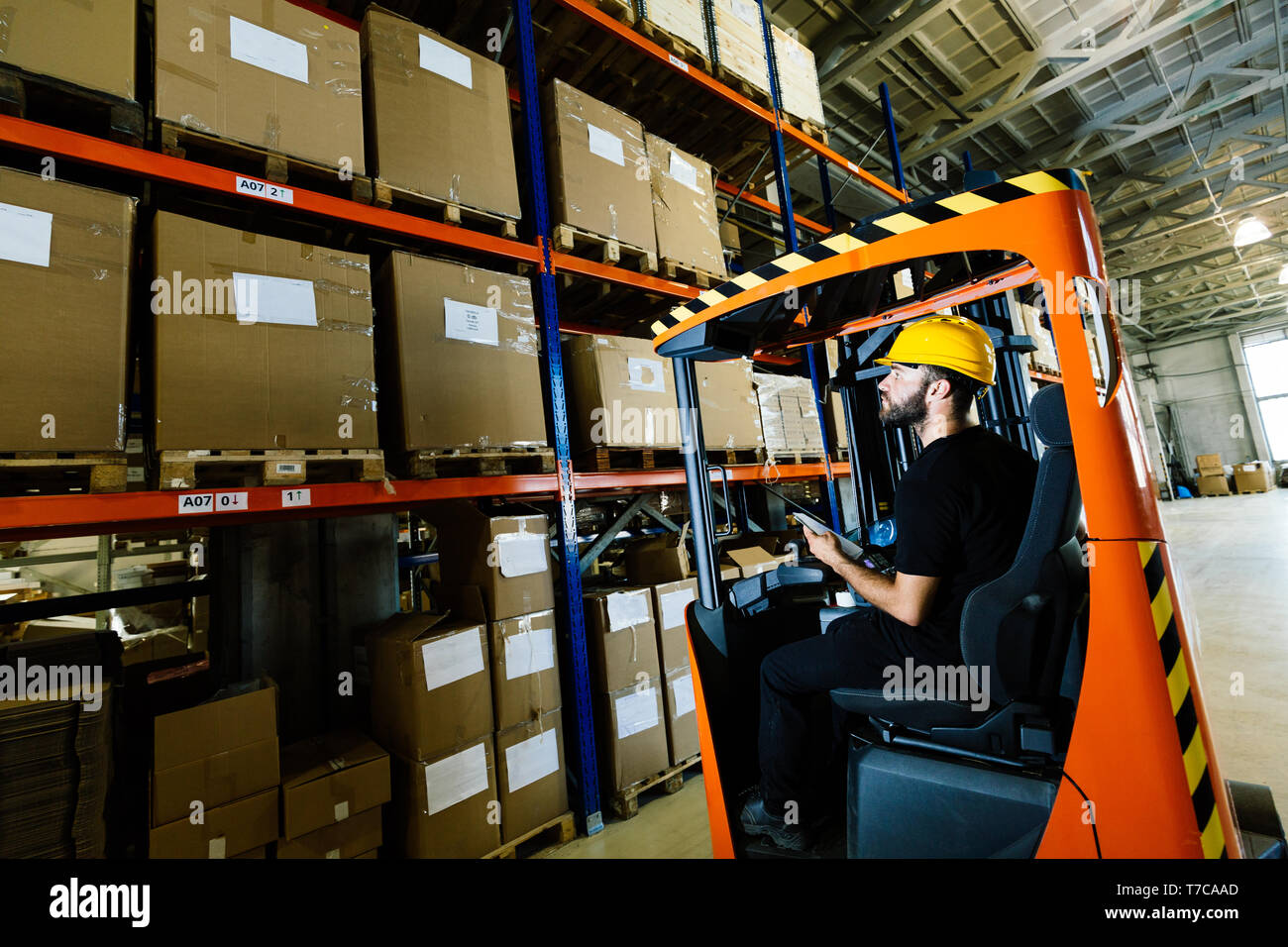Warehouse worker doing logistics work with forklift loader Stock Photo ...