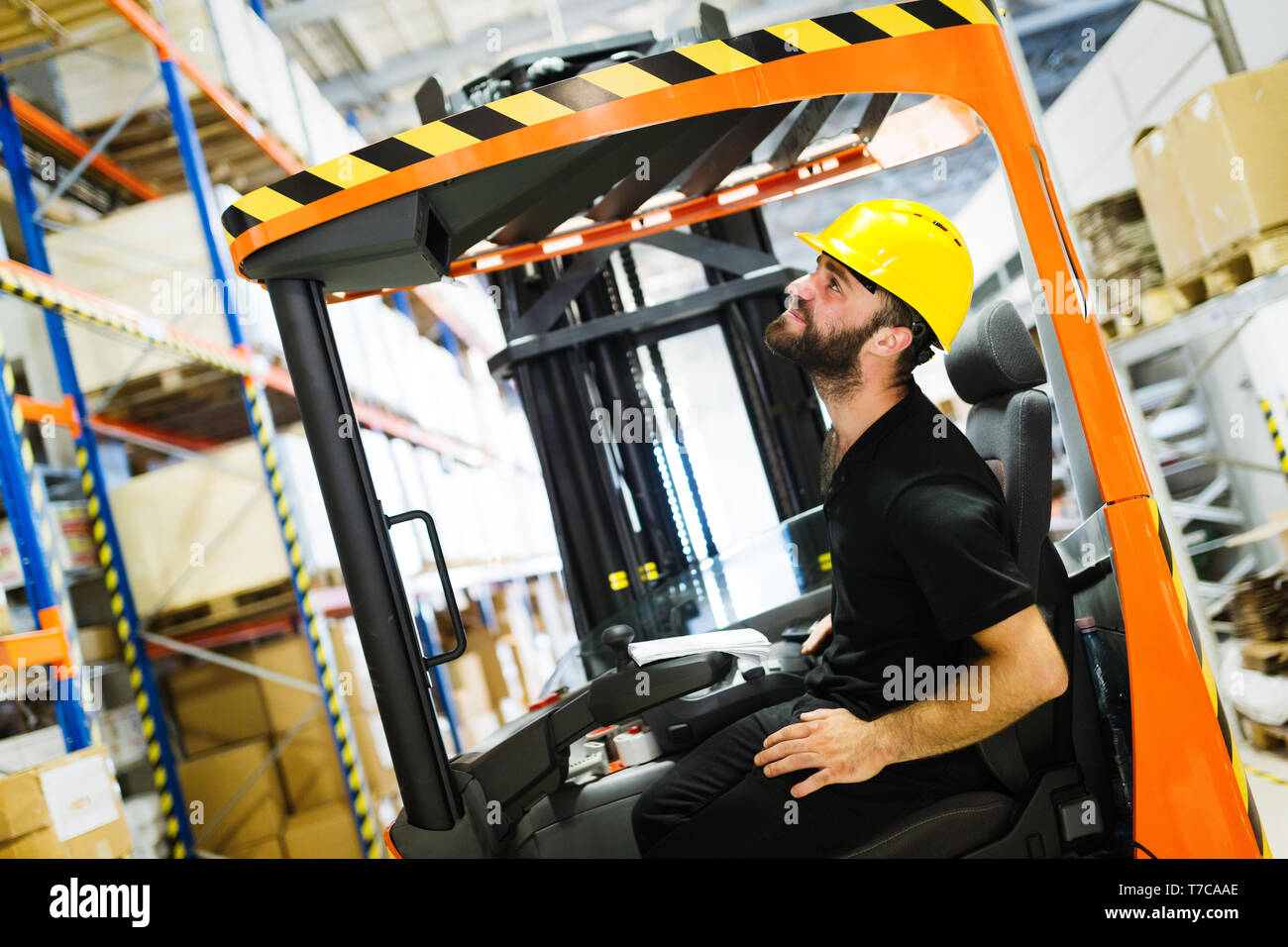 Warehouse worker doing logistics work with forklift loader Stock Photo ...