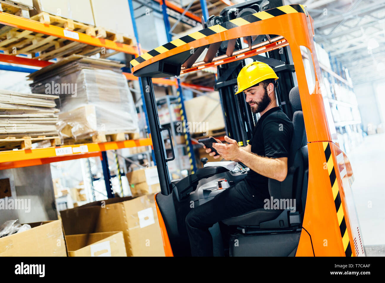 Warehouse worker doing logistics work with forklift loader Stock Photo ...