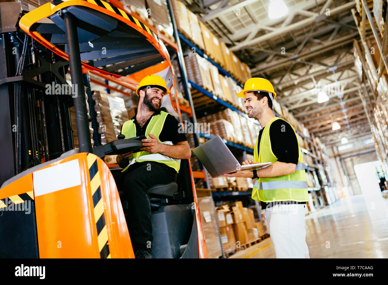 Warehouse workers working together with forklift loader Stock Photo - Alamy