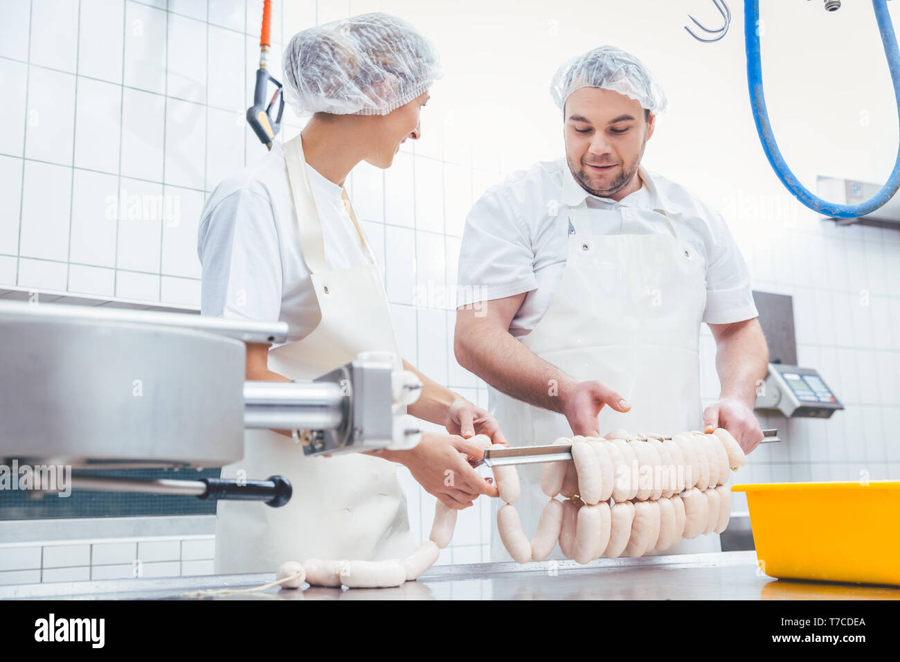 Team of butchers filling sausage in meat industry Stock Photo - Alamy