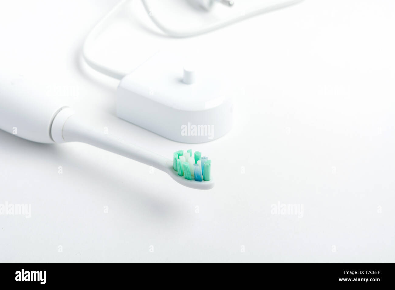 A part of electrical toothbrush with charger on white background with ...