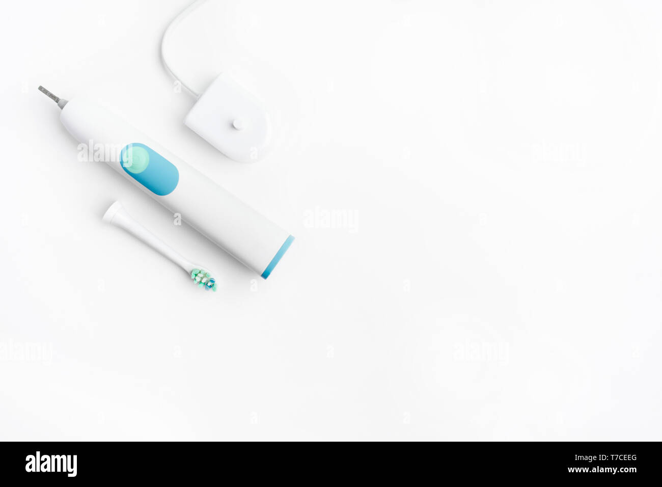 White electric toothbrush with charger over white background with copy ...